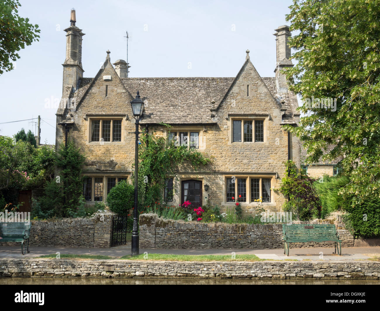 House on the banks of River Windrush in the Cotswold village of Bourton ...