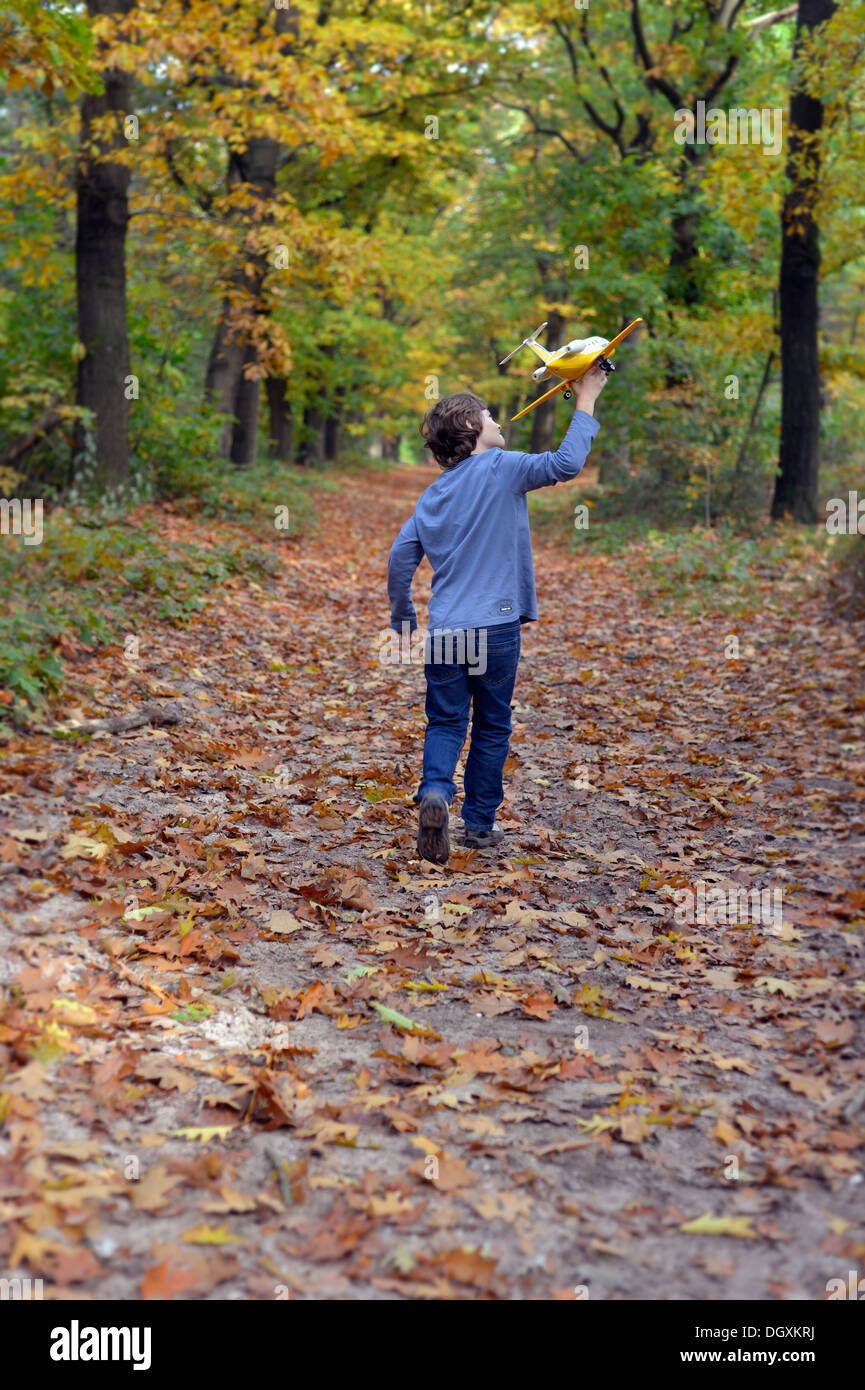 Young boy playing with a toy airplane in a forest Stock Photo - Alamy