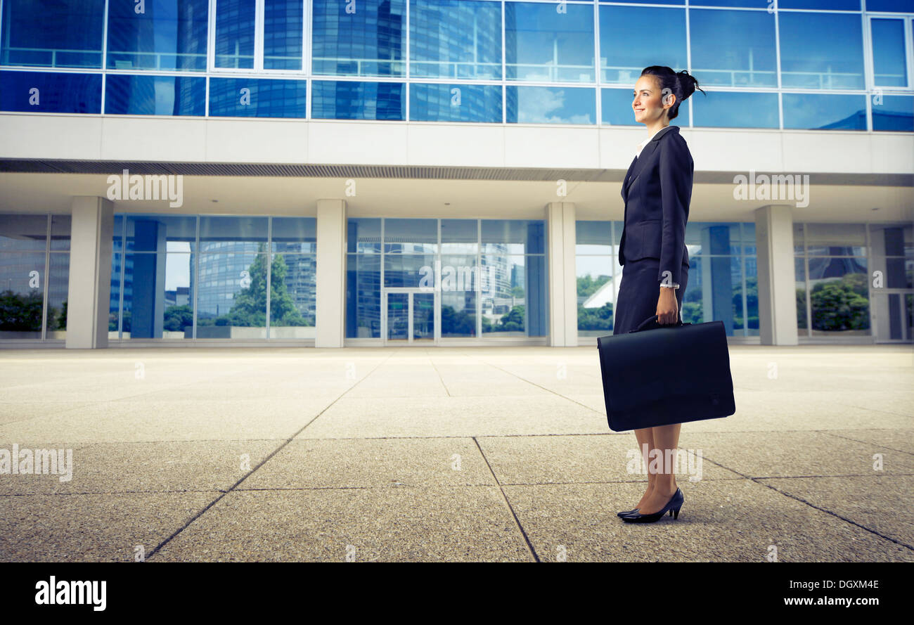 Secretary with a blue dress standing near a modern building Stock Photo ...