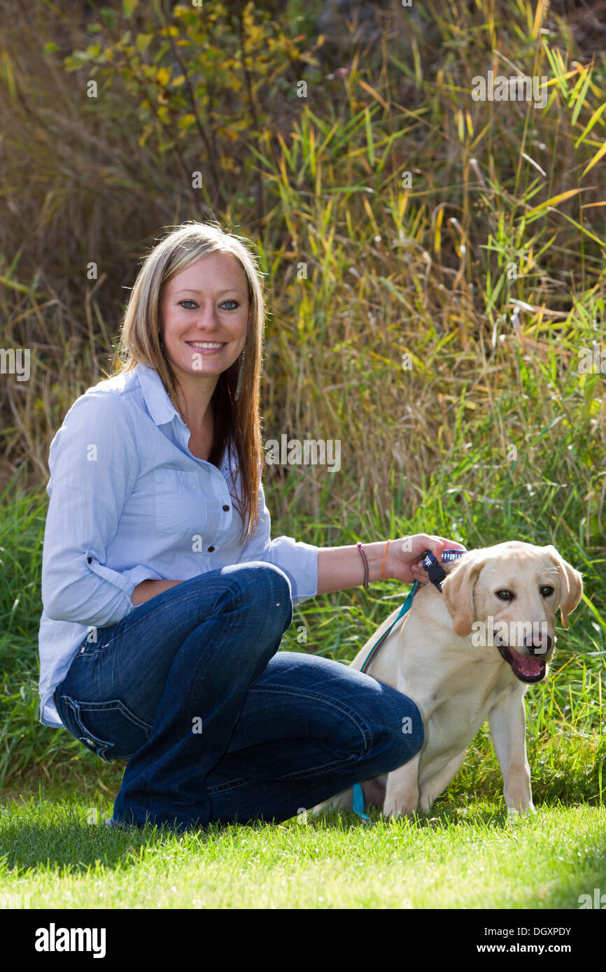 beautiful woman and her new labrador puppy posing outdoors Stock Photo ...