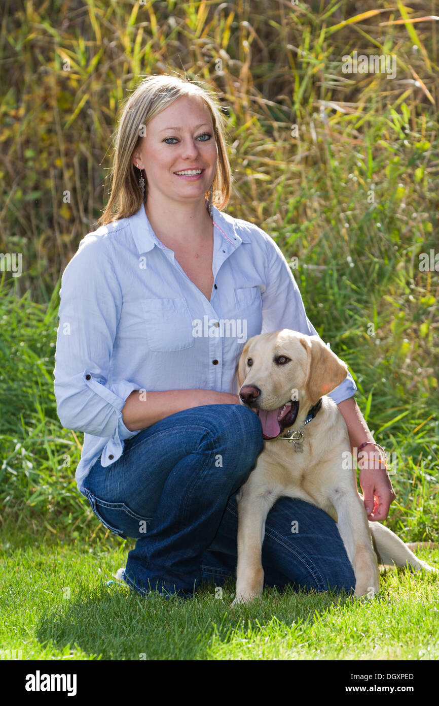 beautiful woman and her new labrador puppy posing outdoors Stock Photo ...