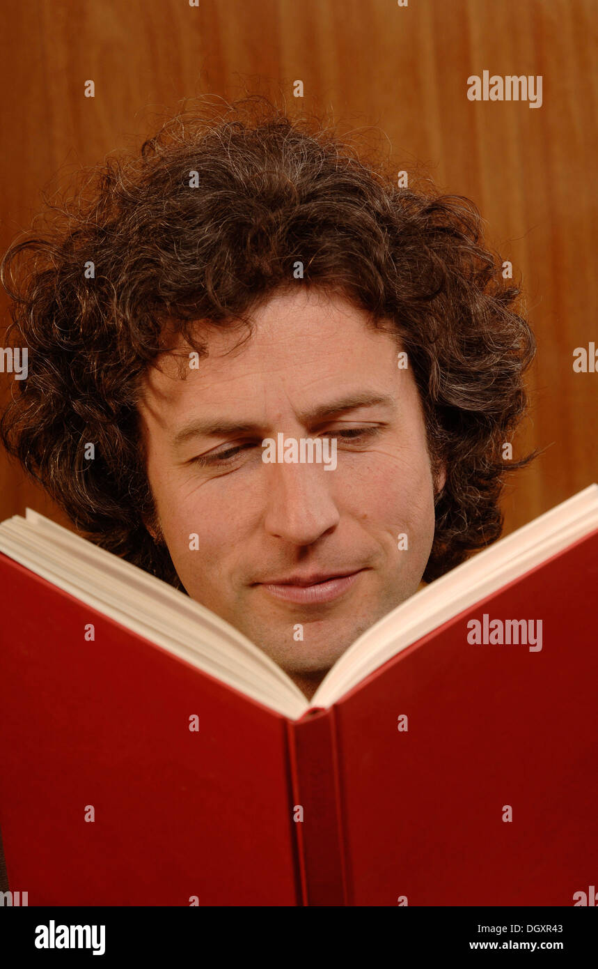 Man, 30-40, reading a red book Stock Photo - Alamy