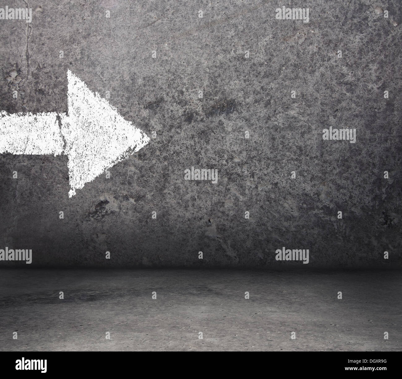 Concrete room with arrow on the wall pointing to right Stock Photo - Alamy
