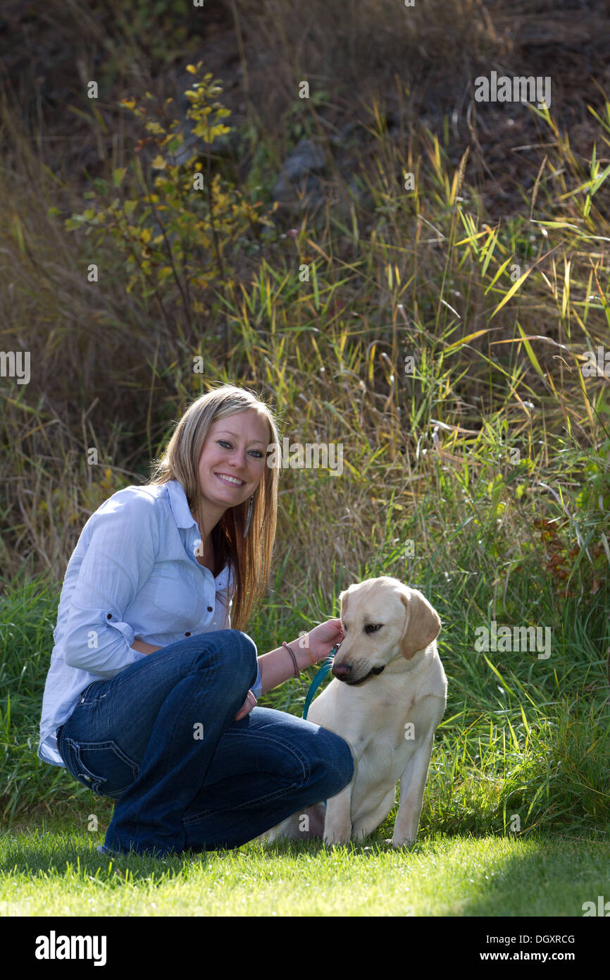 beautiful woman and her new labrador puppy posing outdoors Stock Photo ...