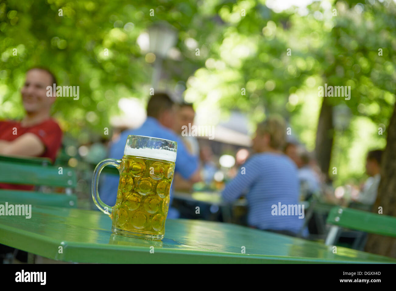 Full beer mug on a table in a beer garden, Englischer Garten, Munich ...