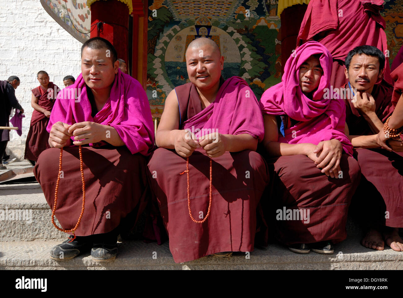 Tibetan monks wearing robes of the Gelug or Gelug-pa Order sitting in ...