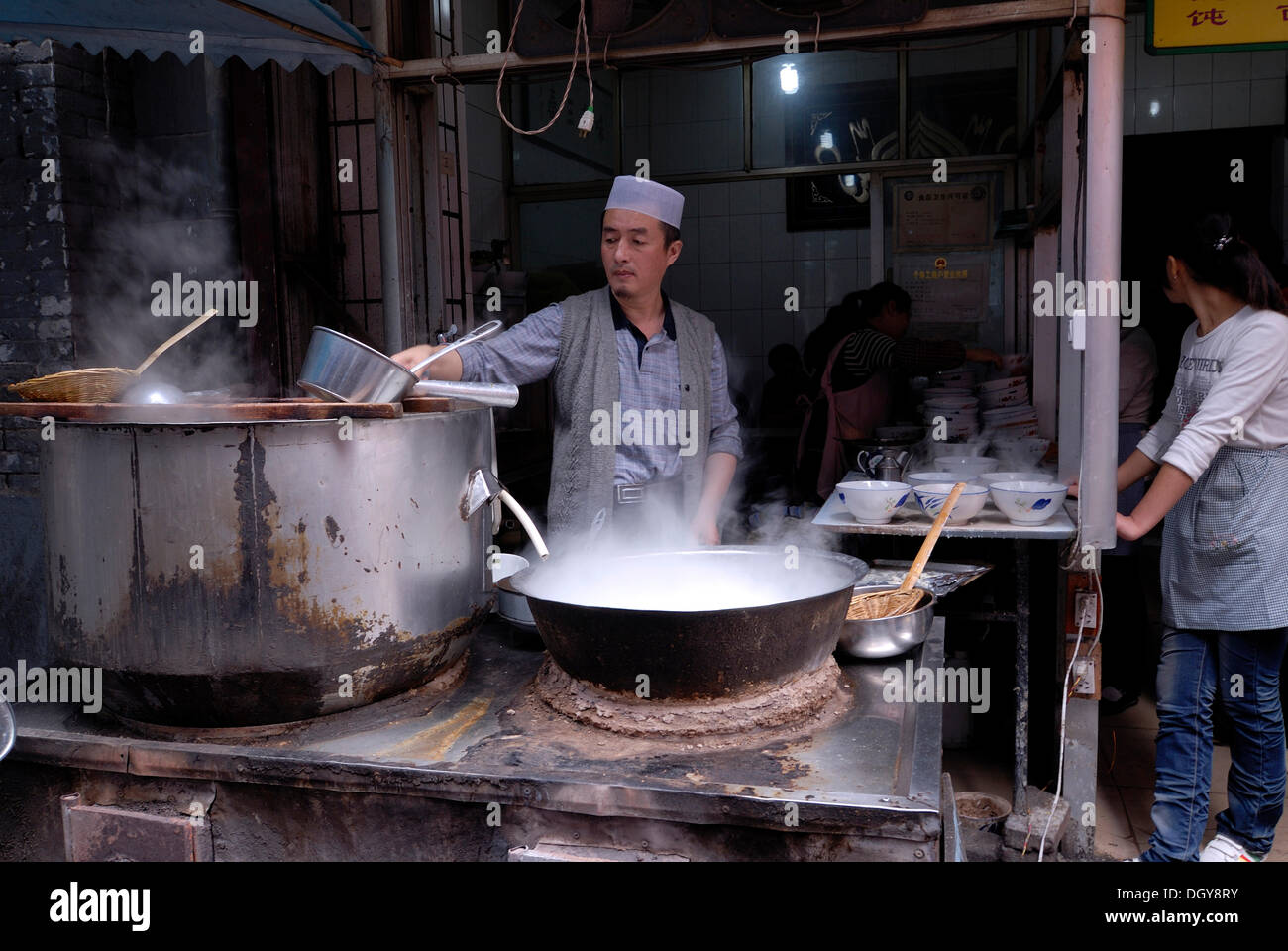 Muslim noodle soup kitchen with a Muslim cook and large steaming pots ...