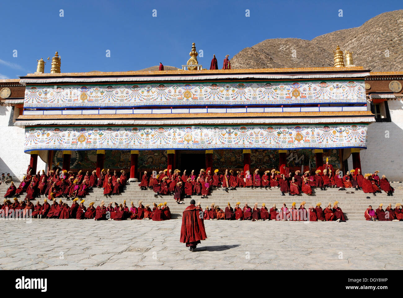 Tibetan monks wearing robes of the Gelug Order sitting on the stairs in ...