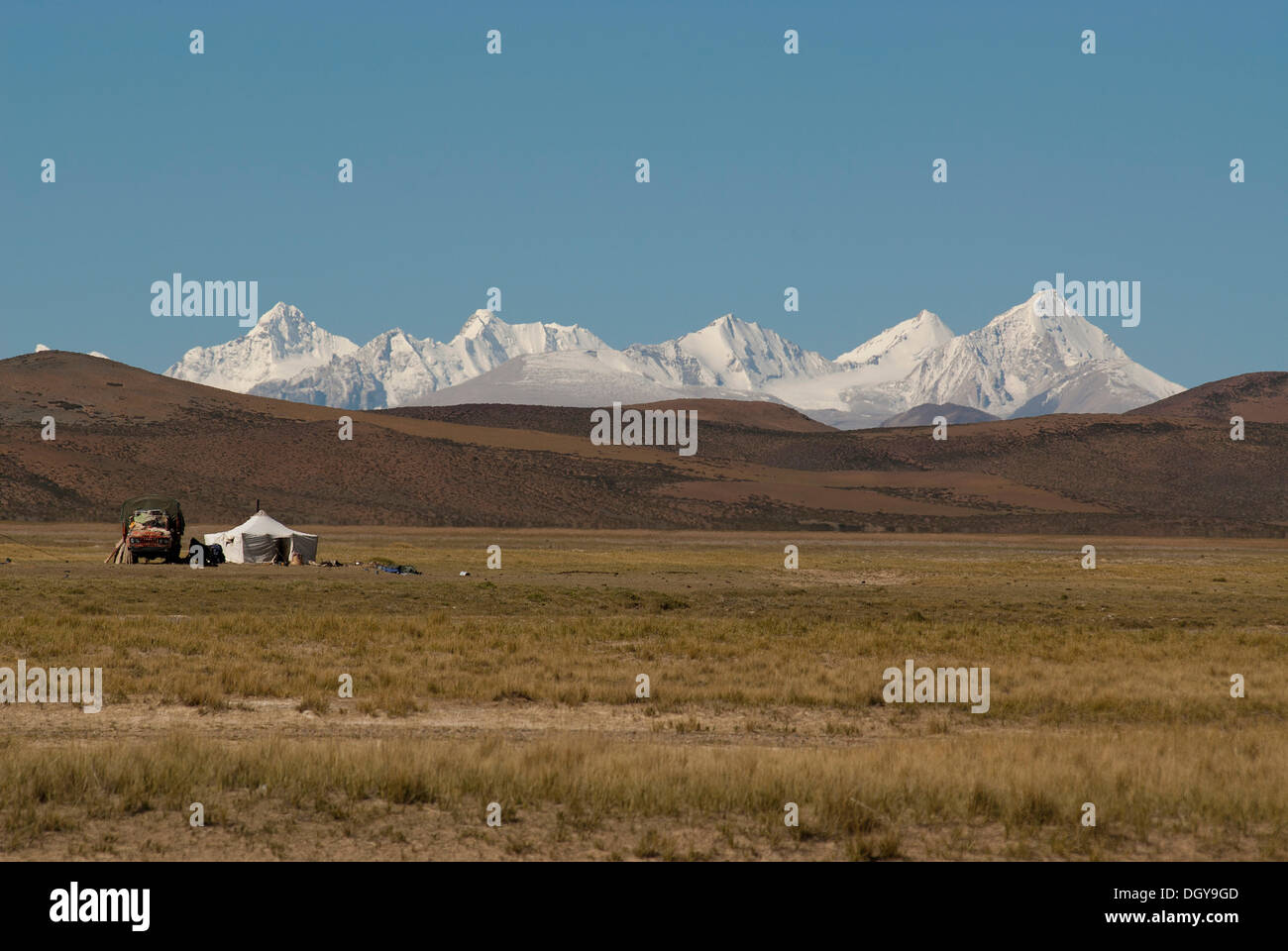 Nomadic tent with a Chinese truck in front of the mighty peaks of the ...
