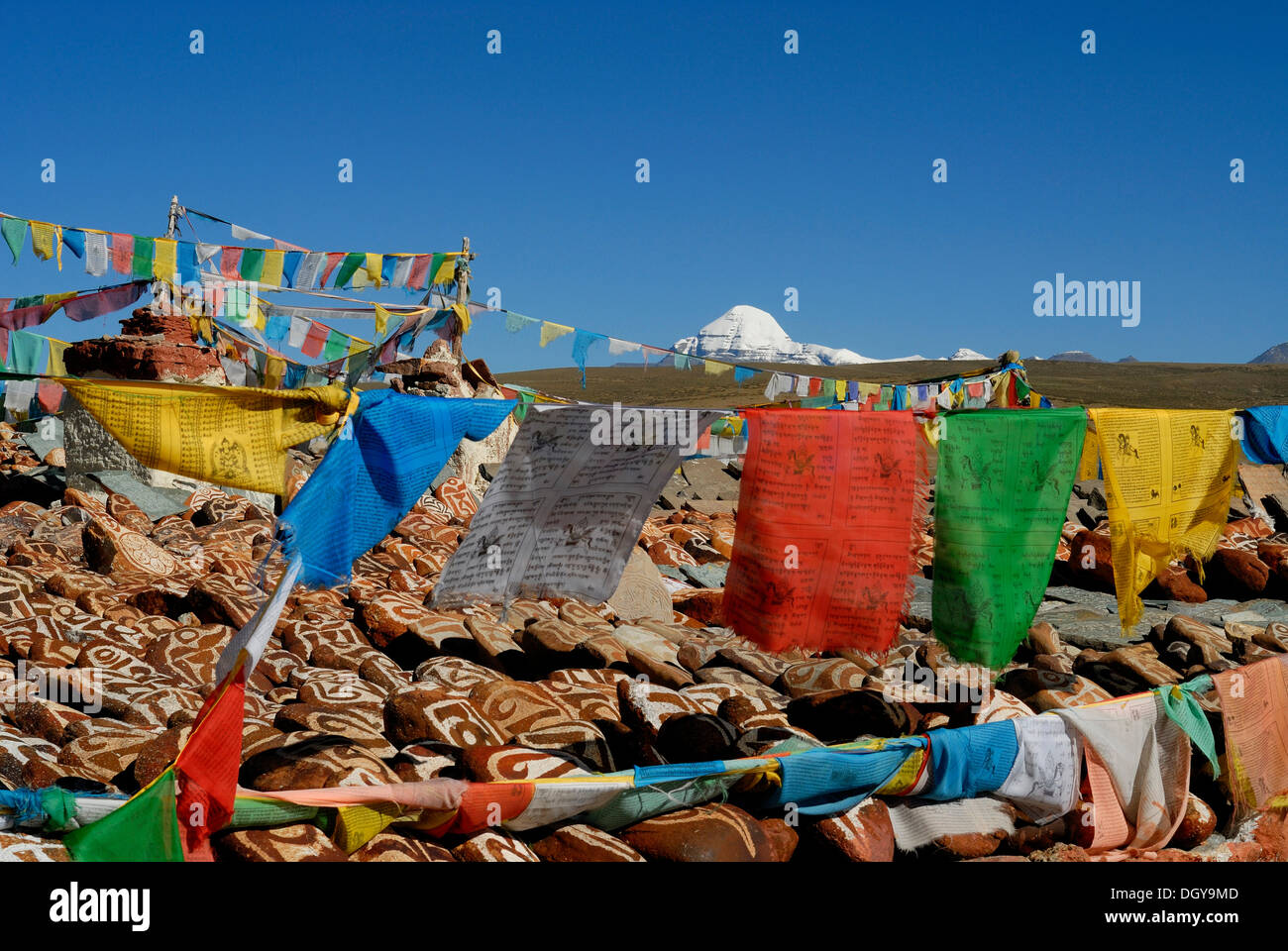 Prayer flags, mani stones and chorten of Chiu Gompa monastery in front ...