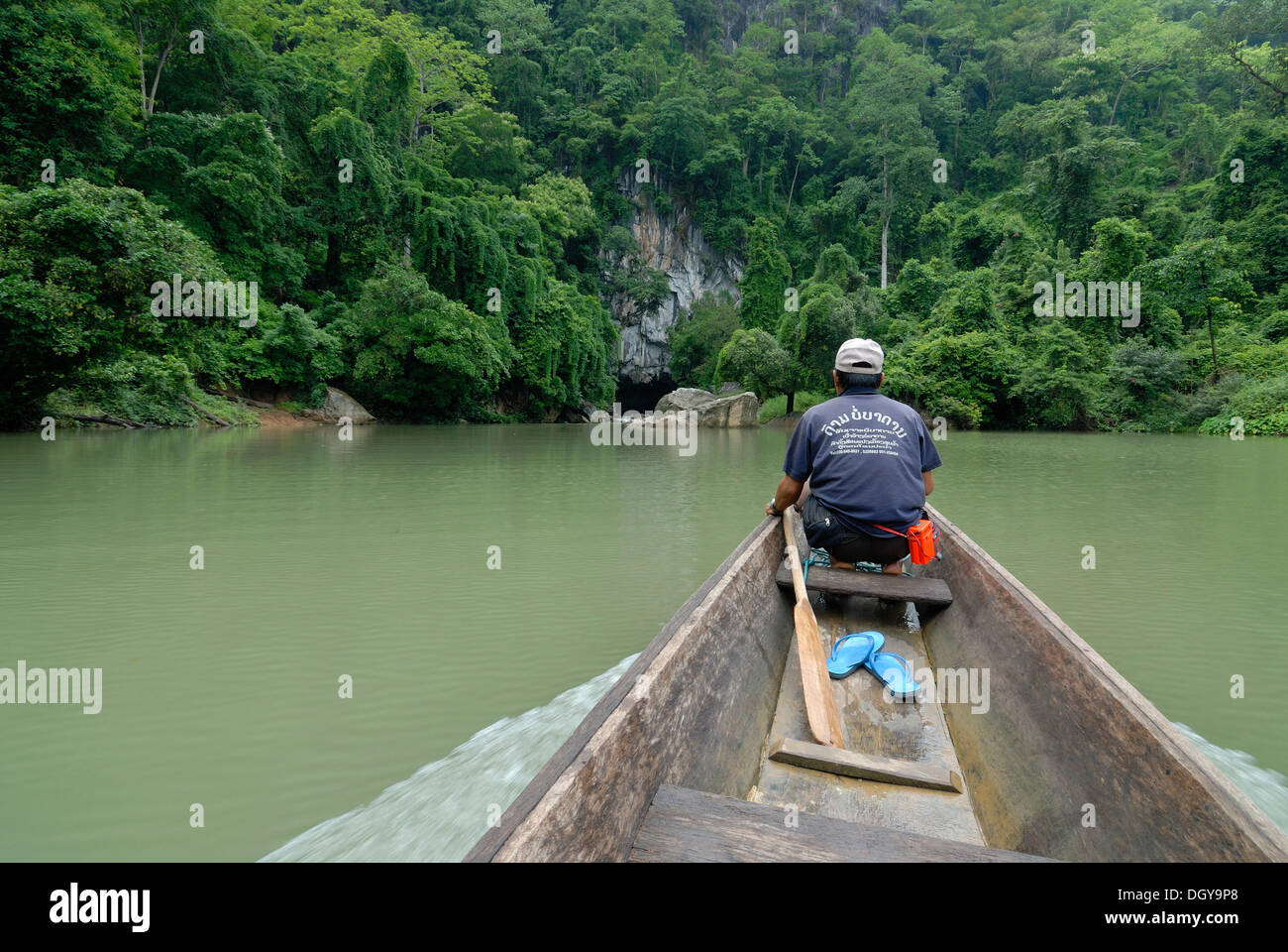 Laotian man with a simple long boat at the entrance of the 7.5 km long ...