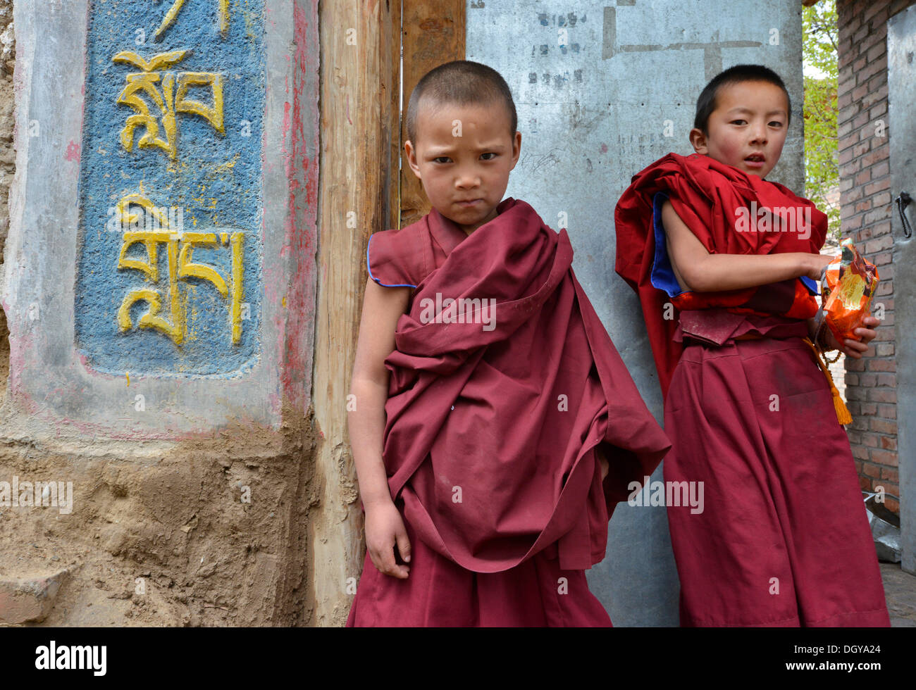 Two young novice monks, students standing in front of the entrance to a ...