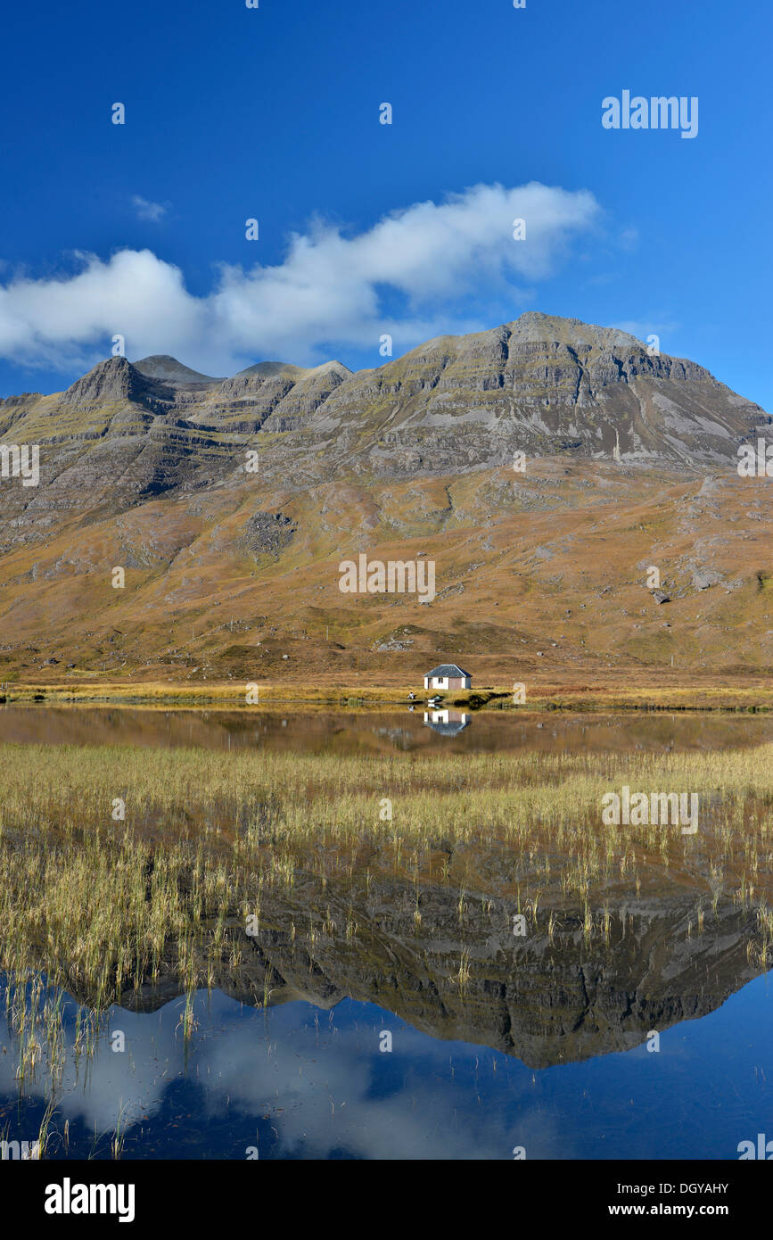Reflection of a boat house in the lake in front of Mt Liathach, Glen ...