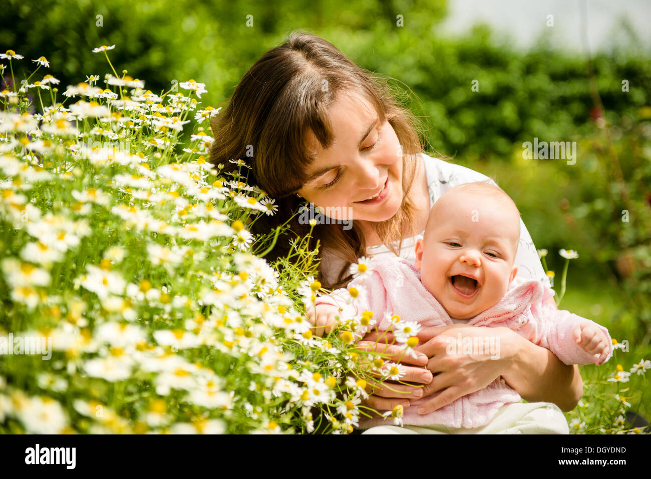 Happy mother with smiling baby in nature (chamomile around Stock Photo ...