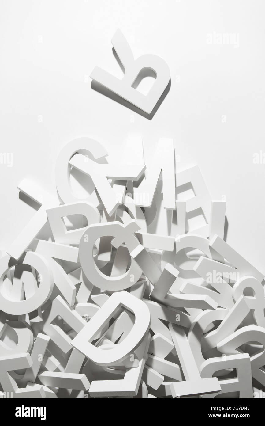A heap of white block letters with the letter R placed above the pile ...