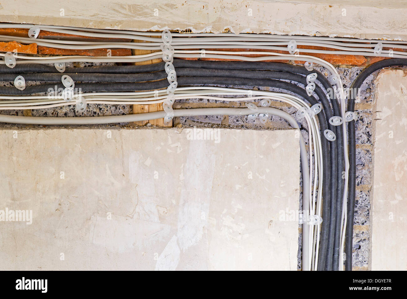 Electric cables laid under plaster in a cable canal in an old building ...