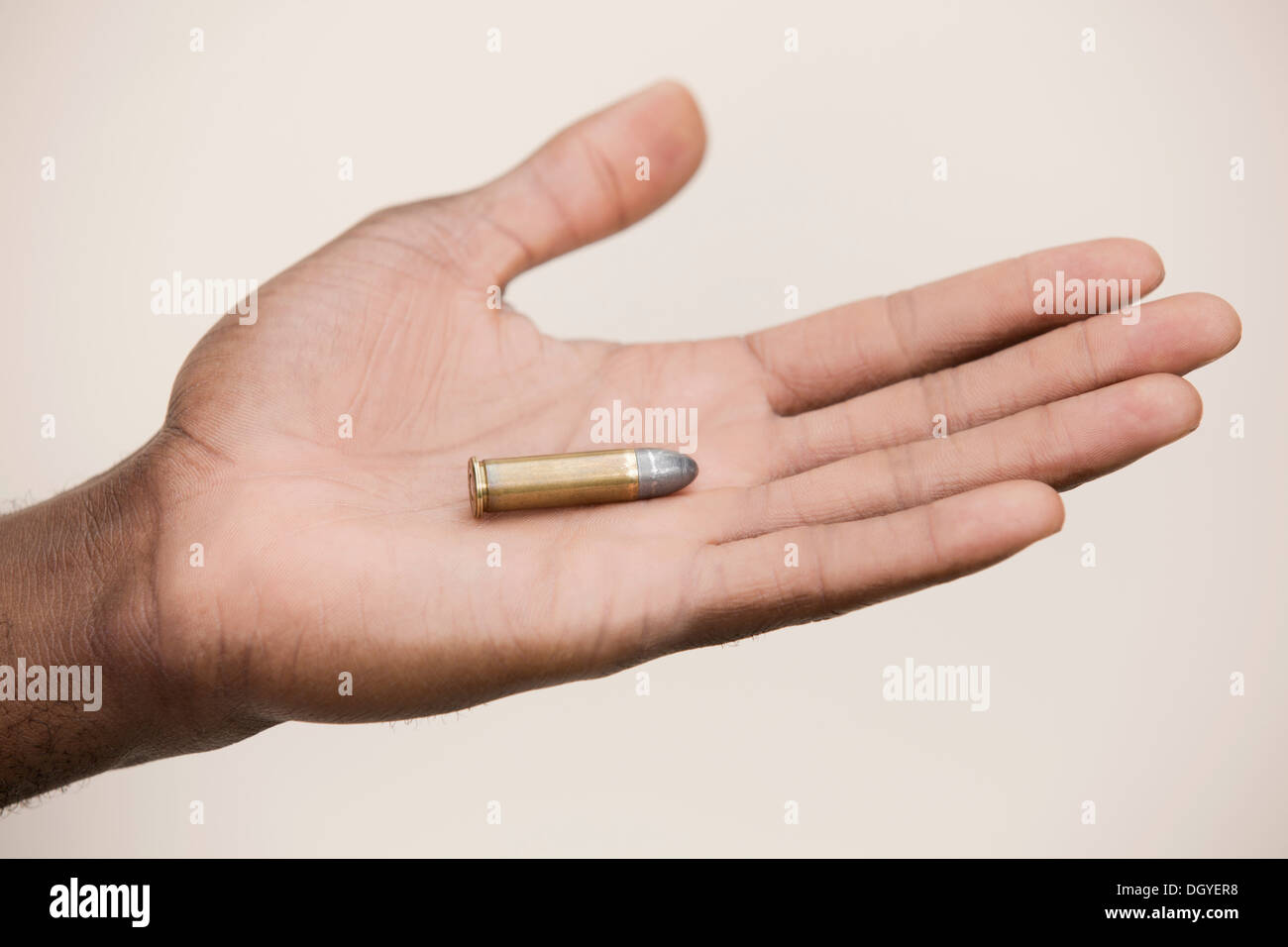 Man holding out a single bullet Stock Photo - Alamy