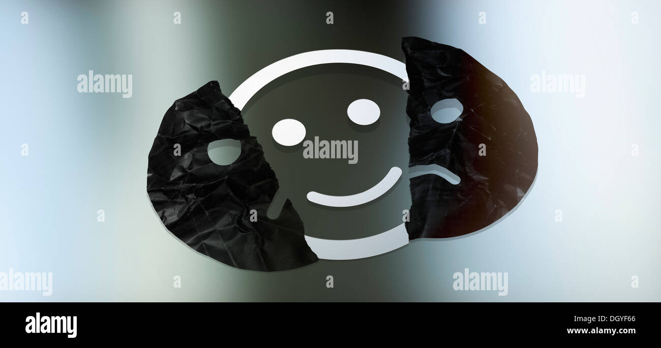 Graphic of a smiley face behind a torn sad face Stock Photo - Alamy
