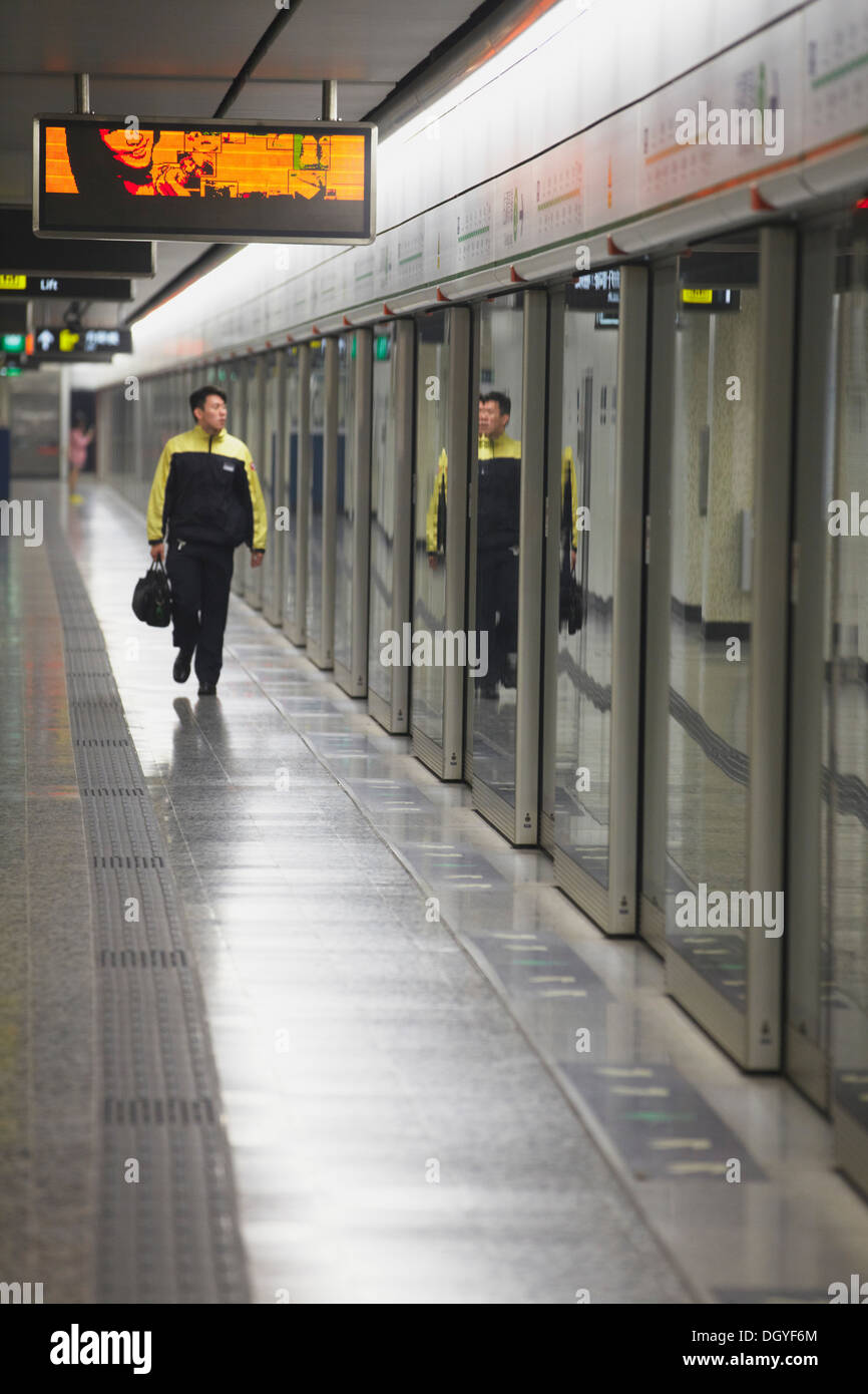 Train driver walking along platform in Mong Kok MTR station, Kowloon ...