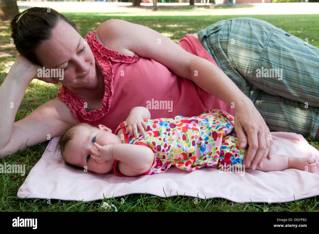 Mother cuddling her baby girl outside in the garden Stock Photo - Alamy