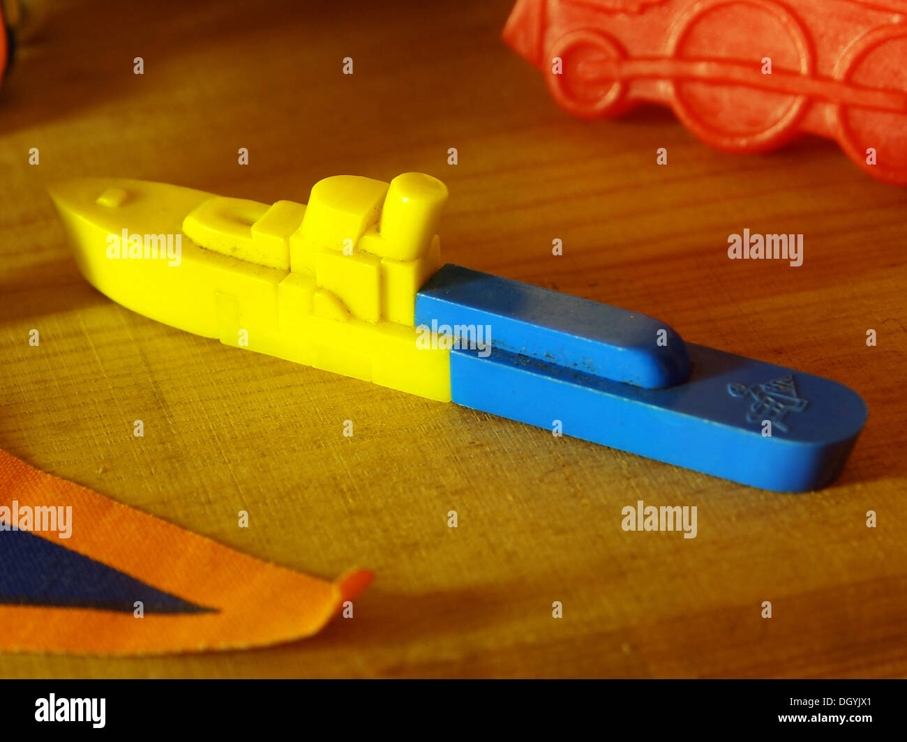 A plastic toy boat, part of a collection of old toys, displayed in a ...