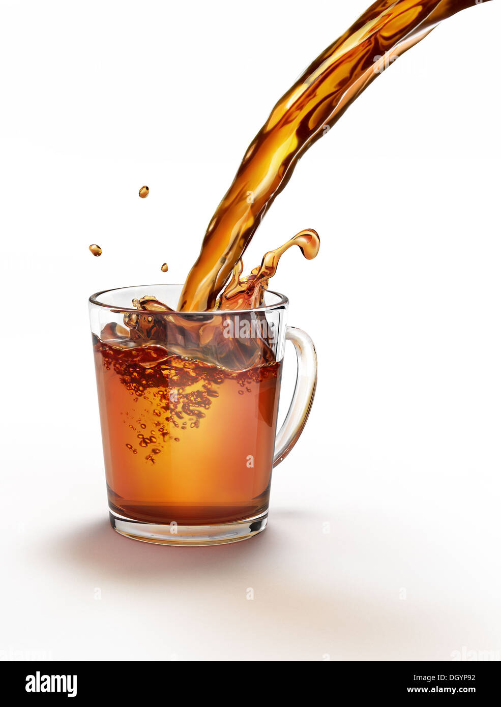 Tea pouring into a glass mug splashing. On a white surface and white ...