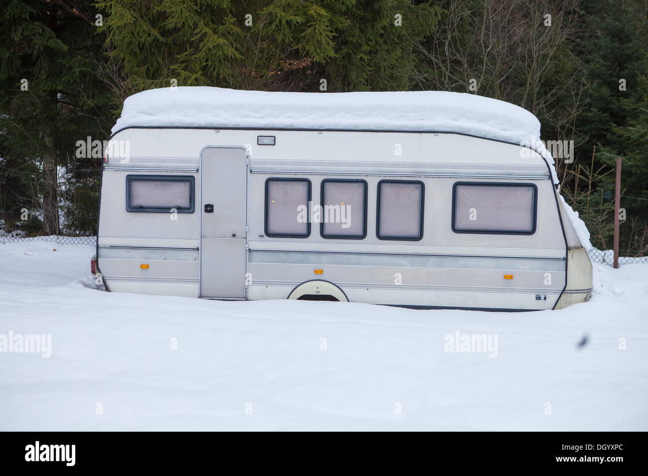 Camper trailer covered with snow Stock Photo - Alamy