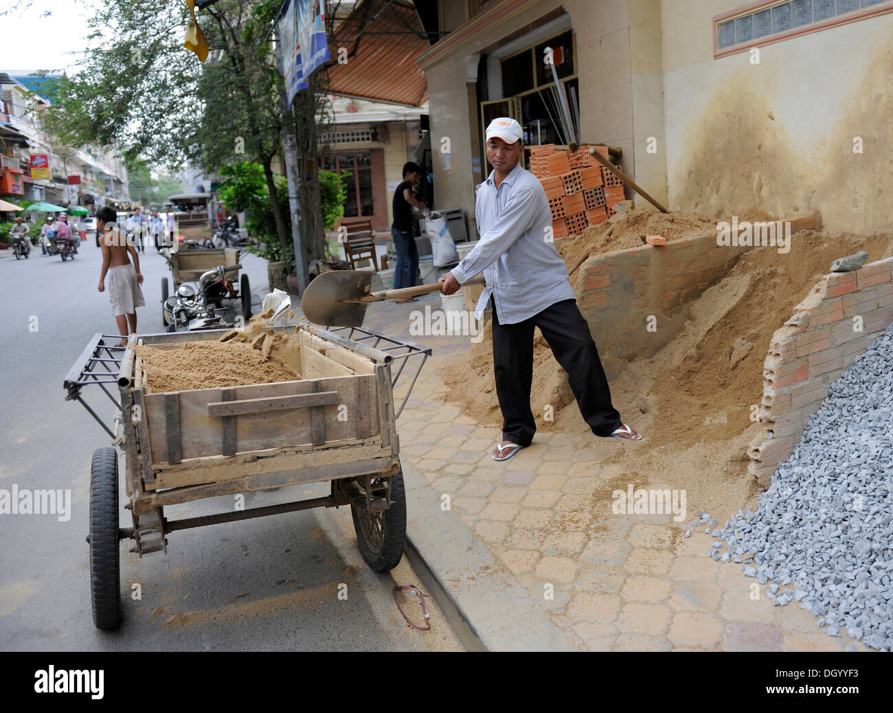 Man filling cart with sand, Phnom Penh, Cambodia, Asia Stock Photo - Alamy