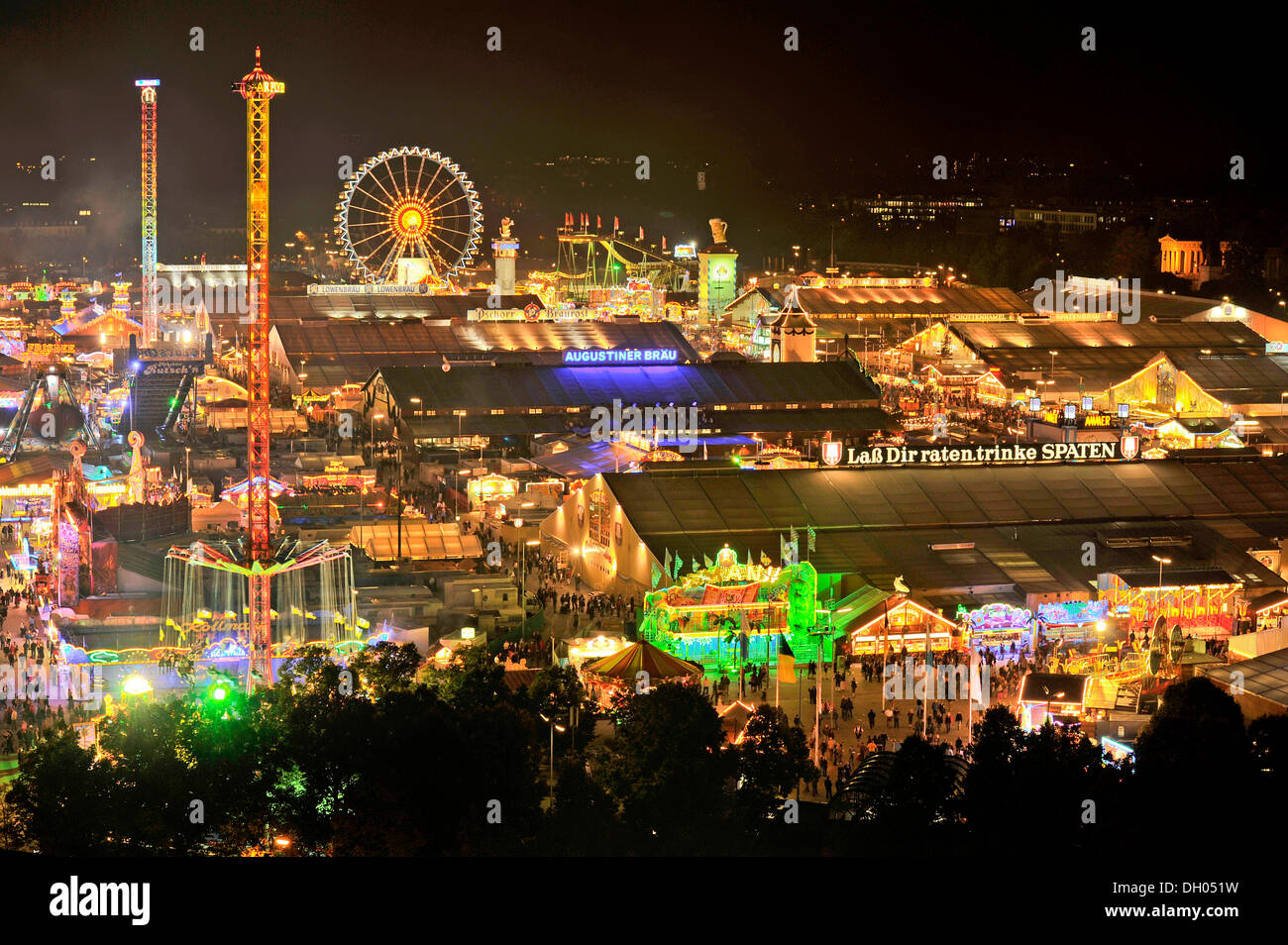 View of the Oktoberfest festival at night, with illuminated stalls ...