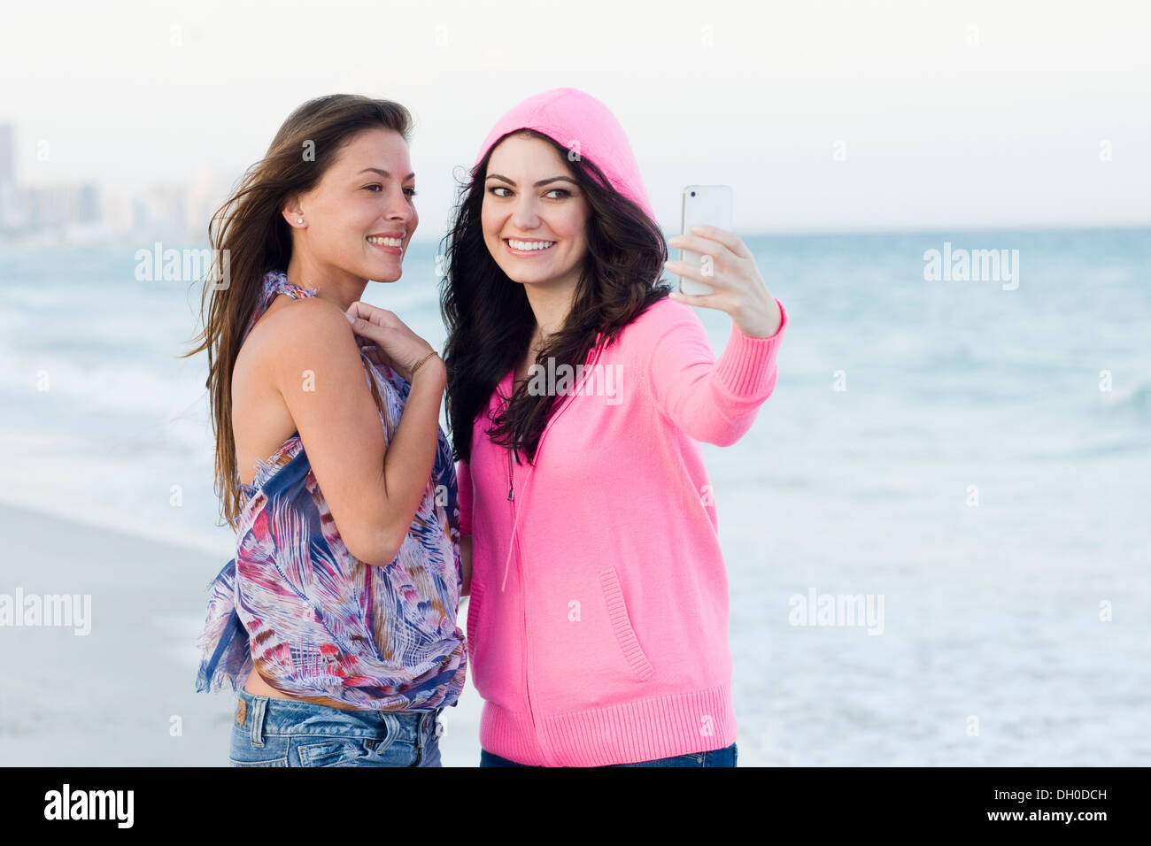 Women taking pictures together on beach Stock Photo - Alamy
