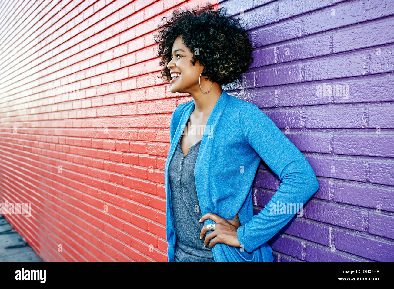 Mixed race woman standing by colorful wall Stock Photo - Alamy