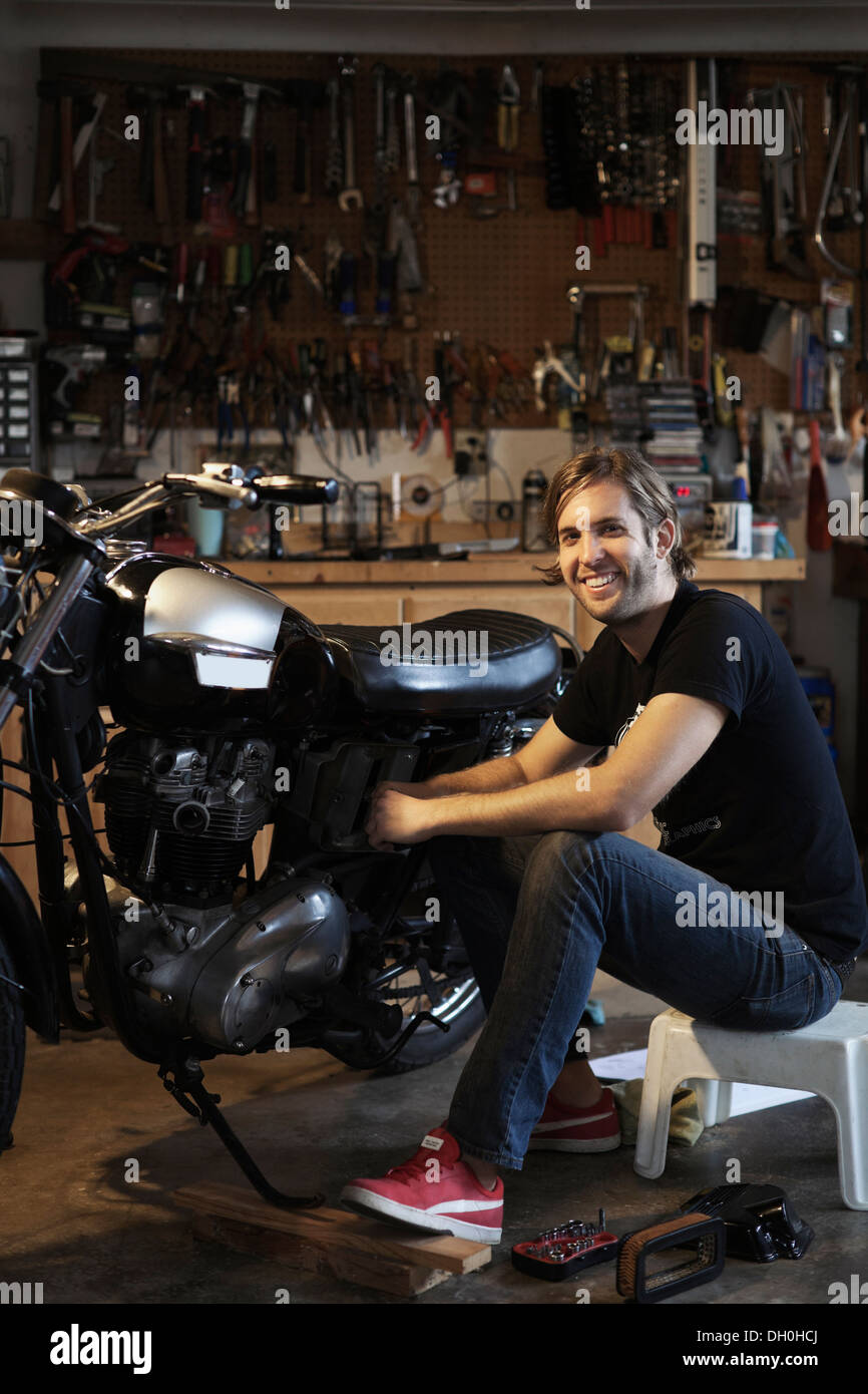 Caucasian mechanic working on motorcycle Stock Photo - Alamy