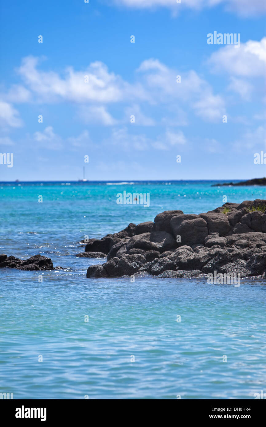 Black stones in the sea. Mauritius Stock Photo - Alamy