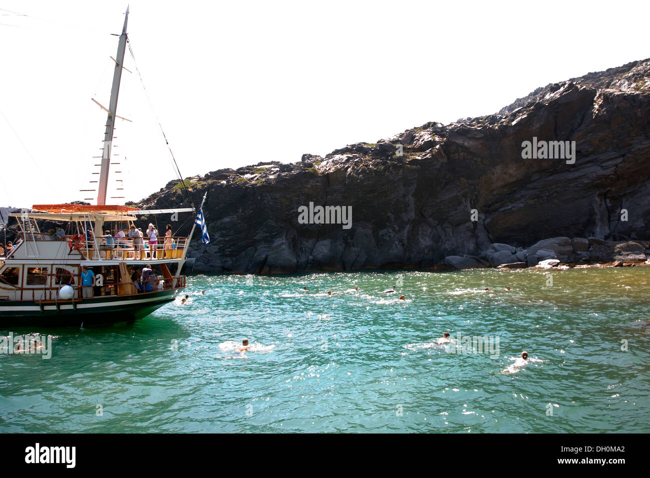 A tour boat at the Hot Springs at the volcano Palea Kameni in Santorini ...
