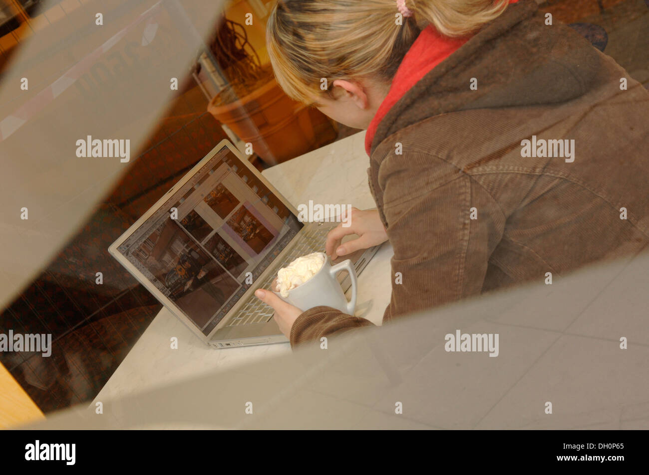 A young woman using photoshop on an Apple Mac laptop computer while ...
