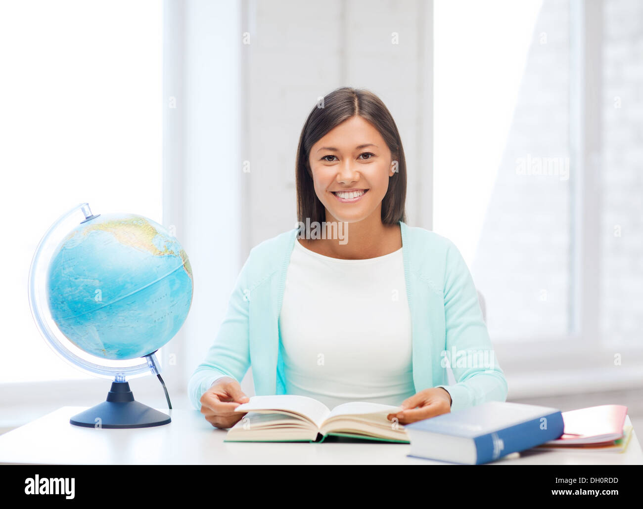 teacher with globe and book at school Stock Photo - Alamy
