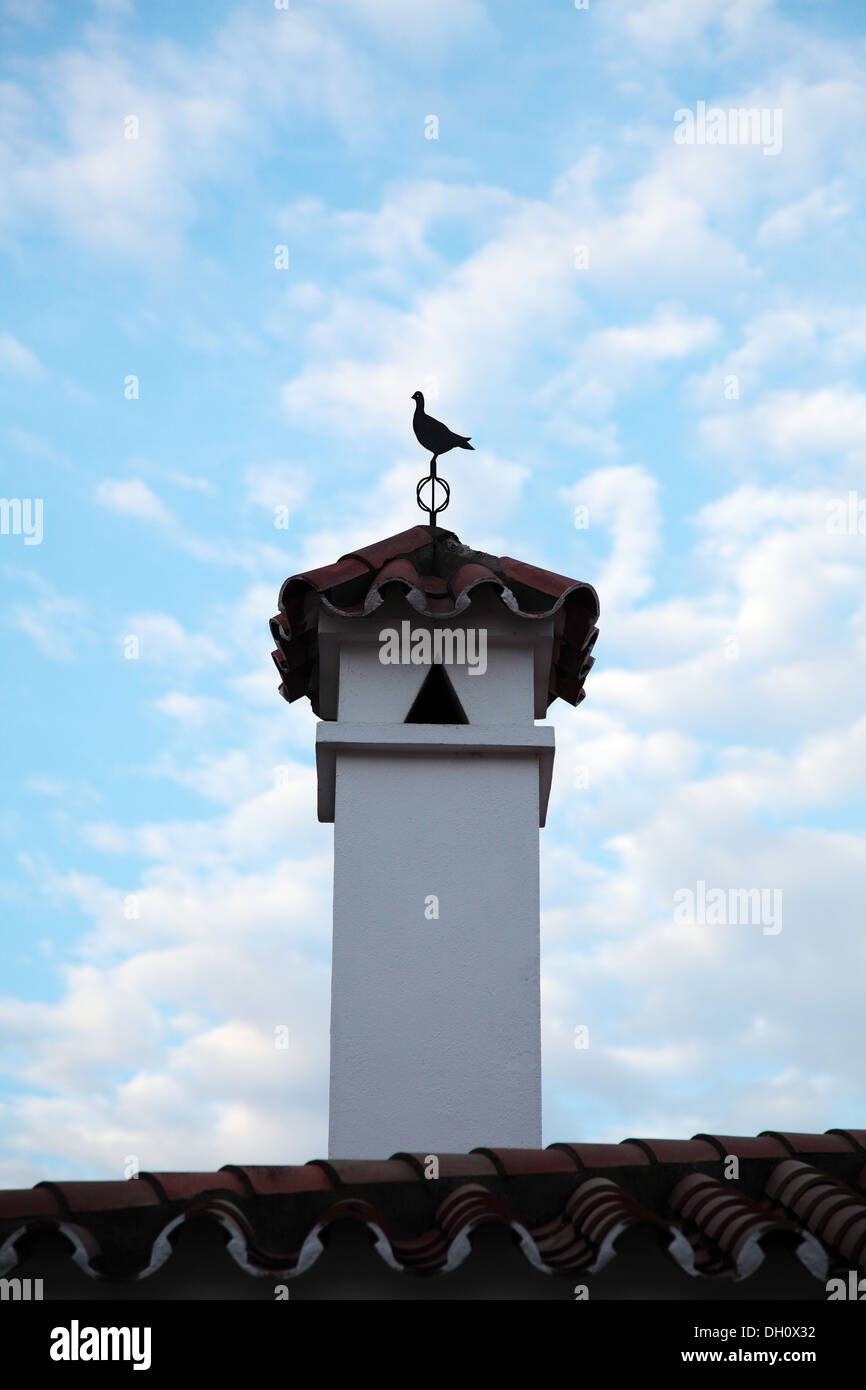 Chimney stack on roof with bird wind vane Stock Photo - Alamy