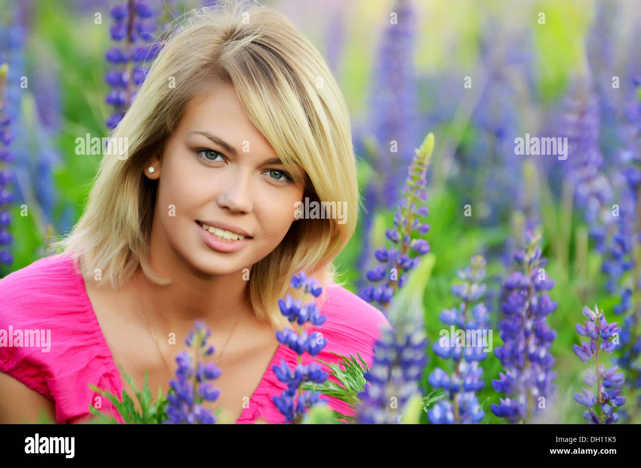 The beautiful woman in the field with lupin Stock Photo - Alamy