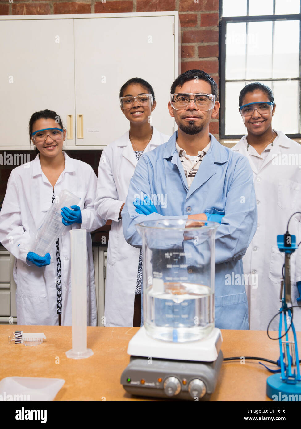 Teacher and students smiling in science lab Stock Photo - Alamy