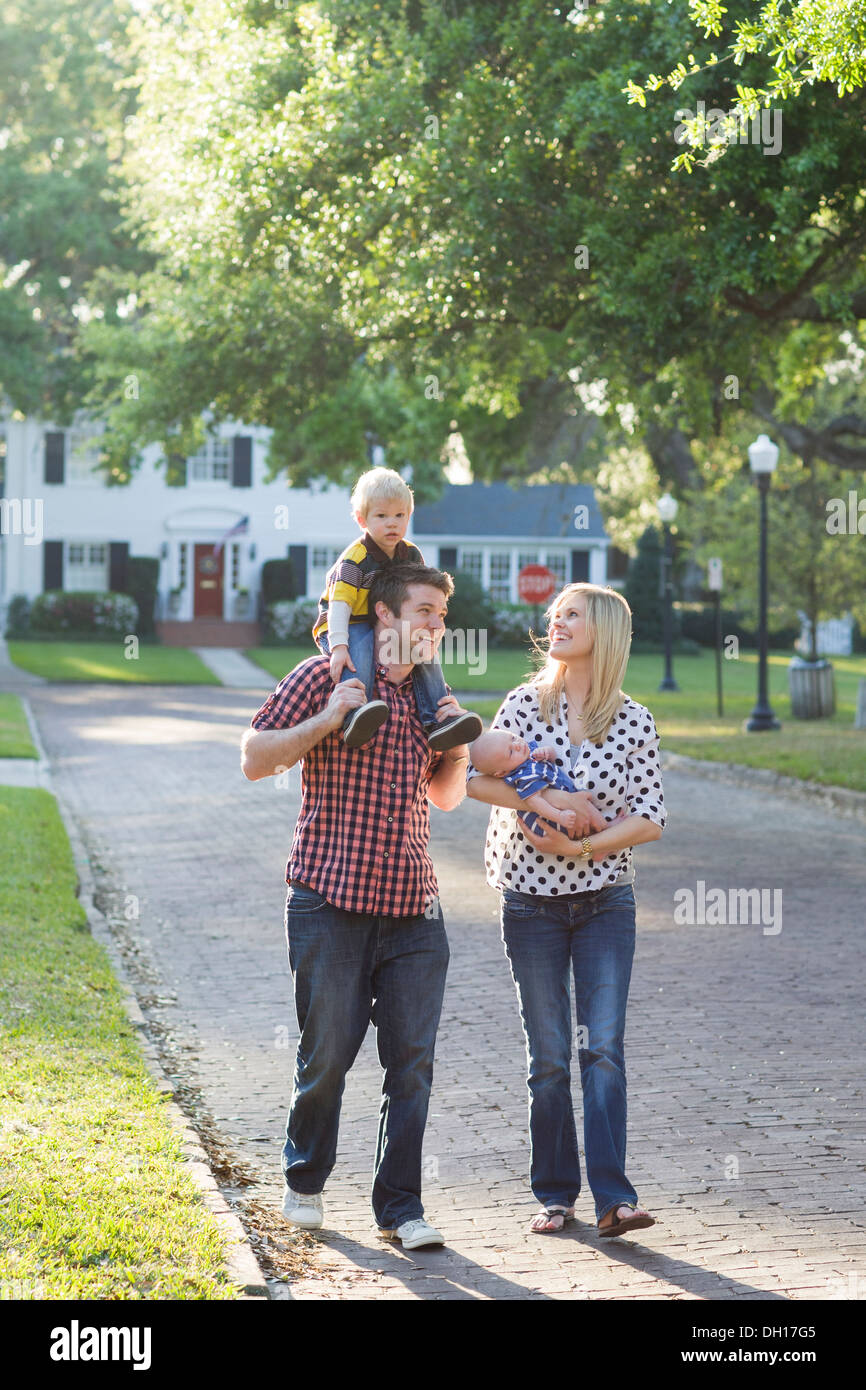 Caucasian family walking along neighborhood street Stock Photo - Alamy