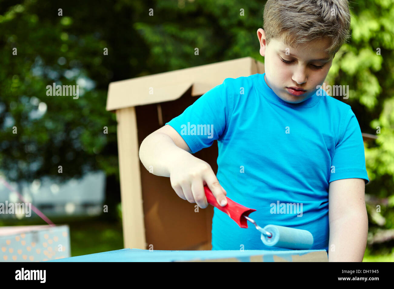 Boy painting cardboard box, Munich, Bavaria, Germany Stock Photo - Alamy