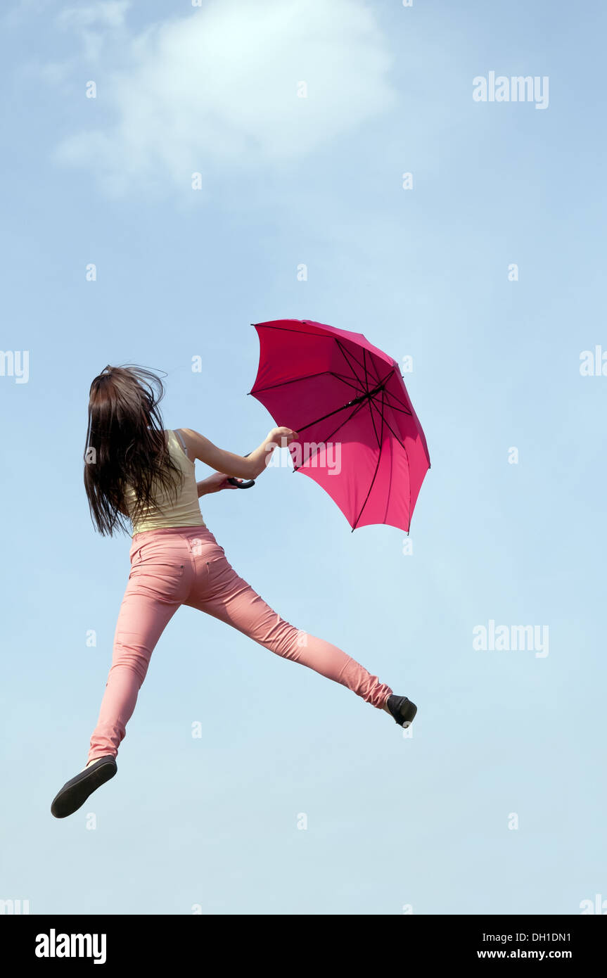 rear view of woman jumping with umbrella Stock Photo - Alamy