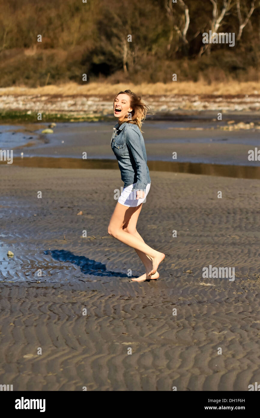 Young woman runs on beach, having fun, Denmark, Europe Stock Photo - Alamy
