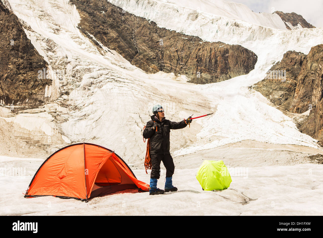 The climber standing near tent on glacier Stock Photo - Alamy