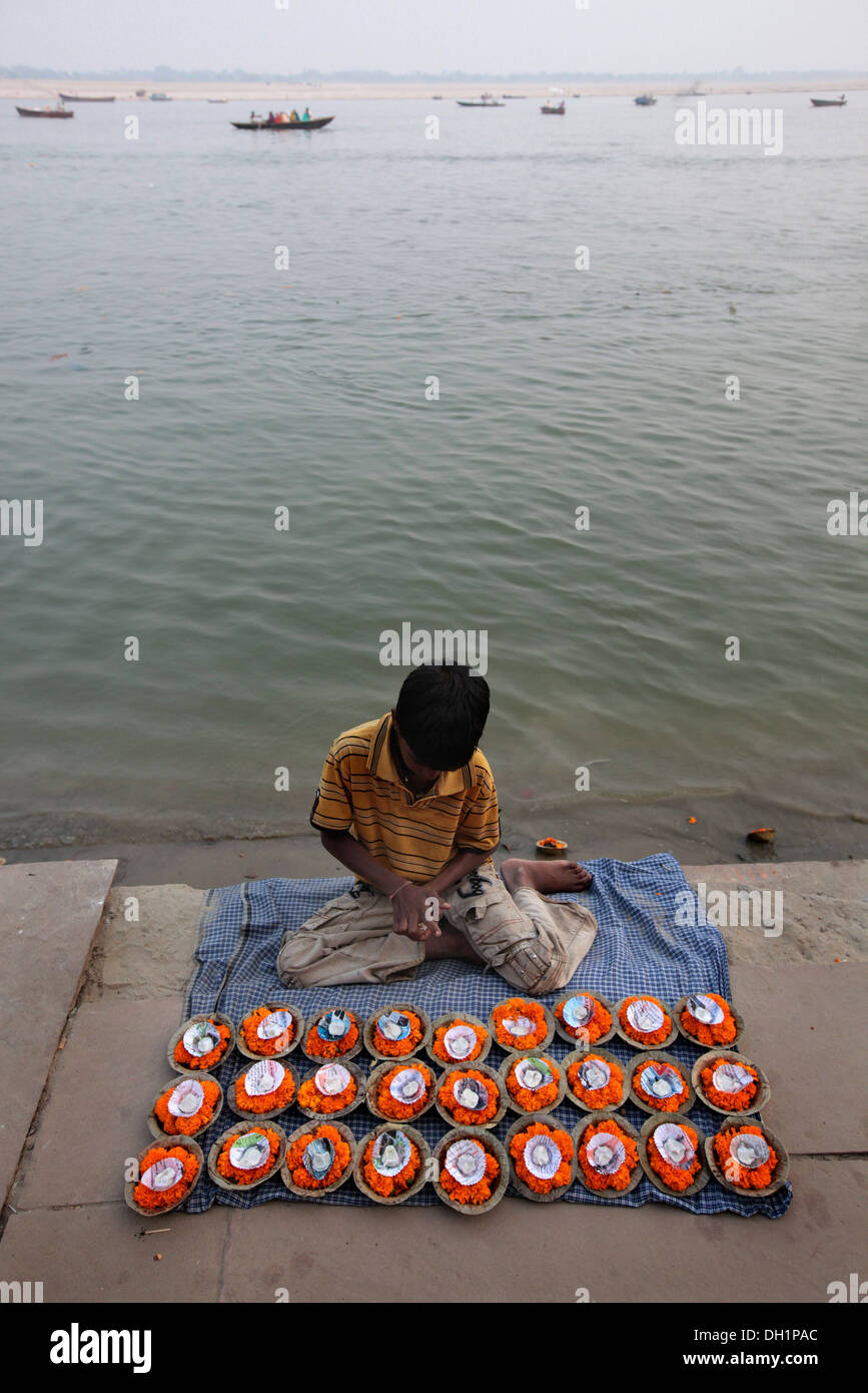 boy selling floating diyas on ghats of Ganga River ganges at Varanasi ...