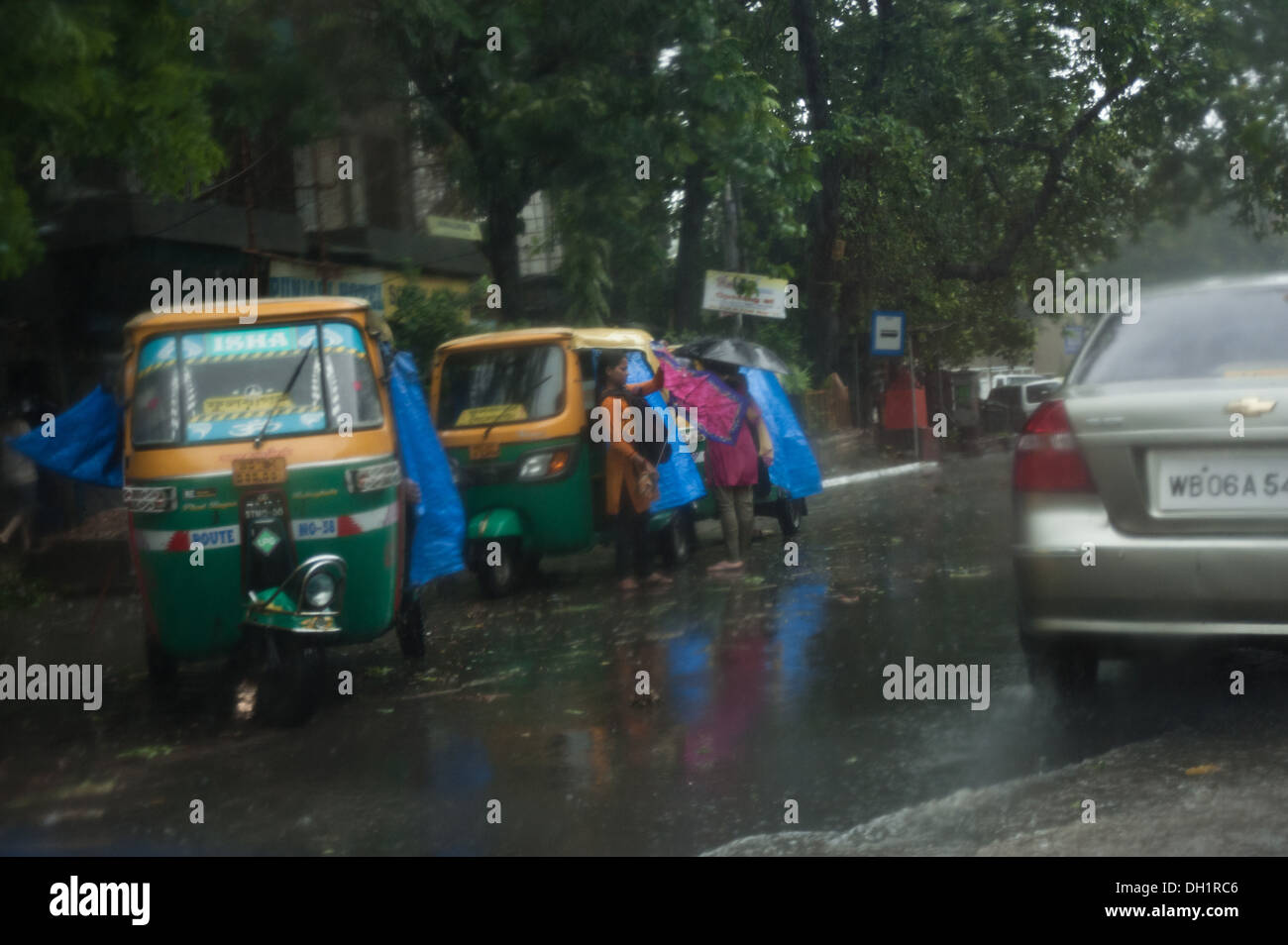auto rickshaws car vehicles street raining monsoon Kolkata west bengal ...