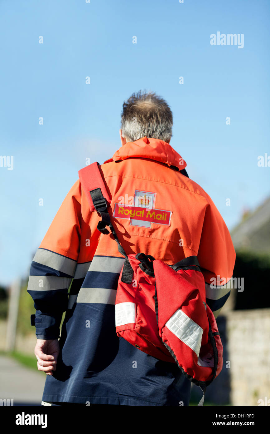 postman walking the street delivering mail Stock Photo - Alamy