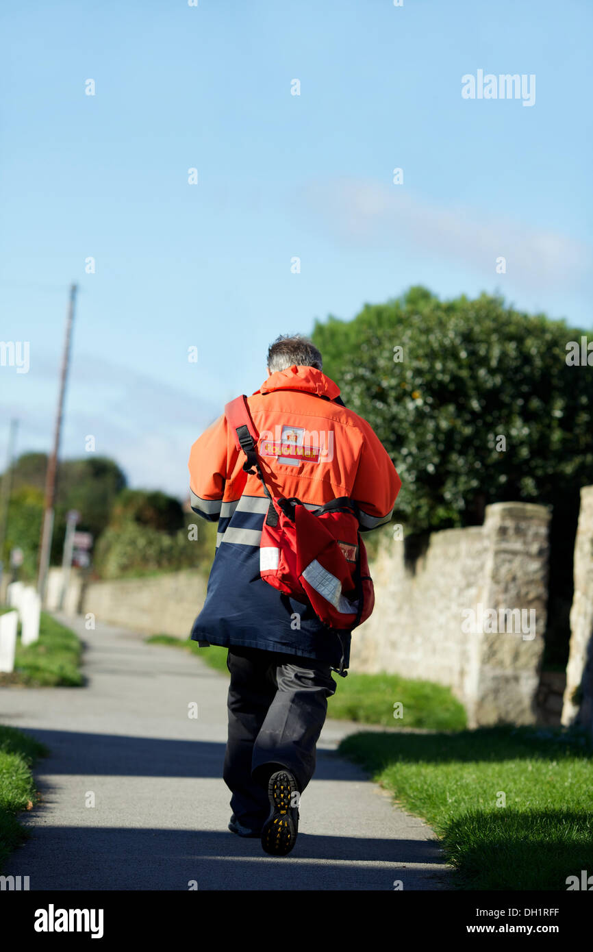 postman walking the street delivering mail Stock Photo - Alamy