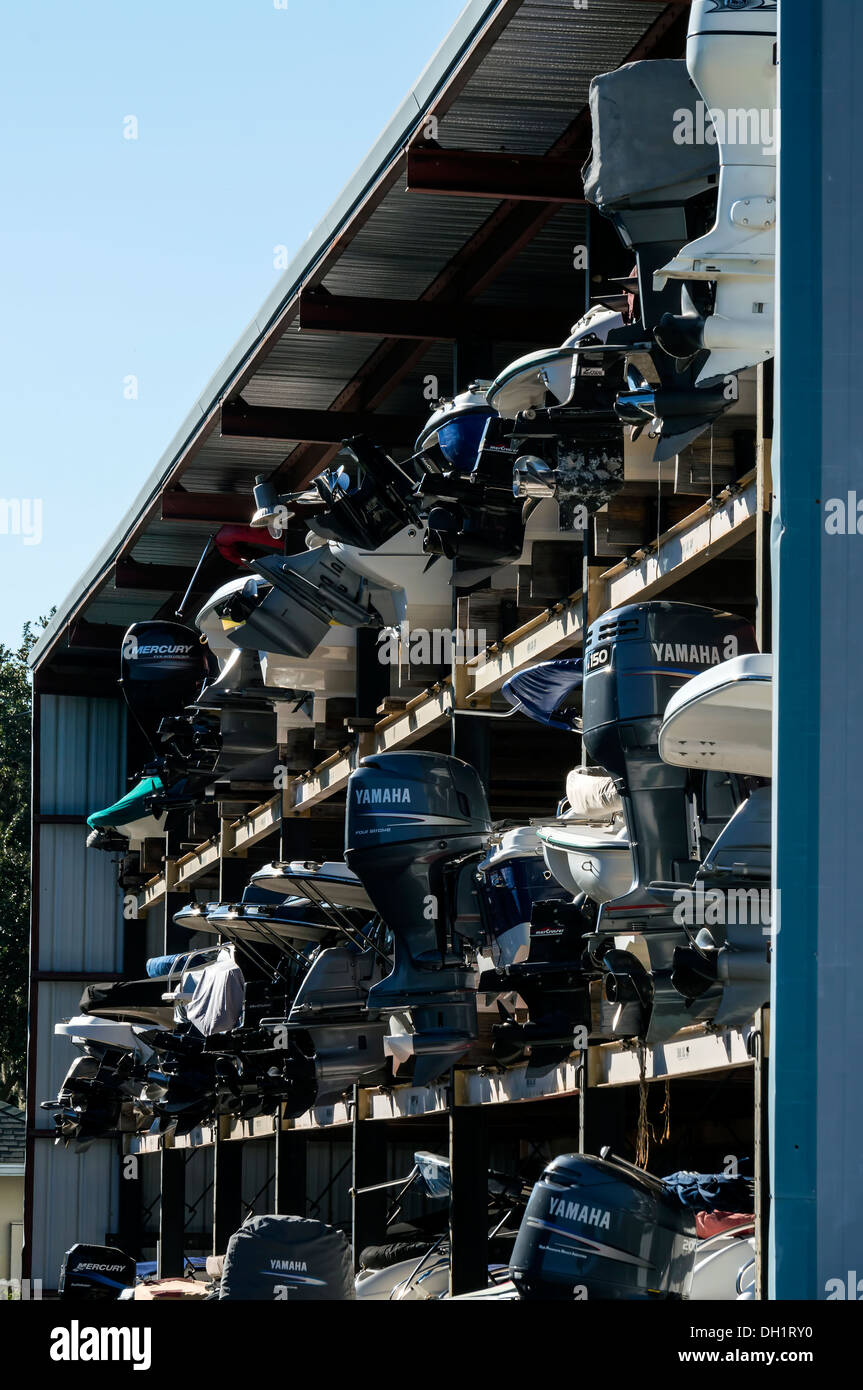 Speed boats with outboard motors engines stacked in dry dock in a steel ...