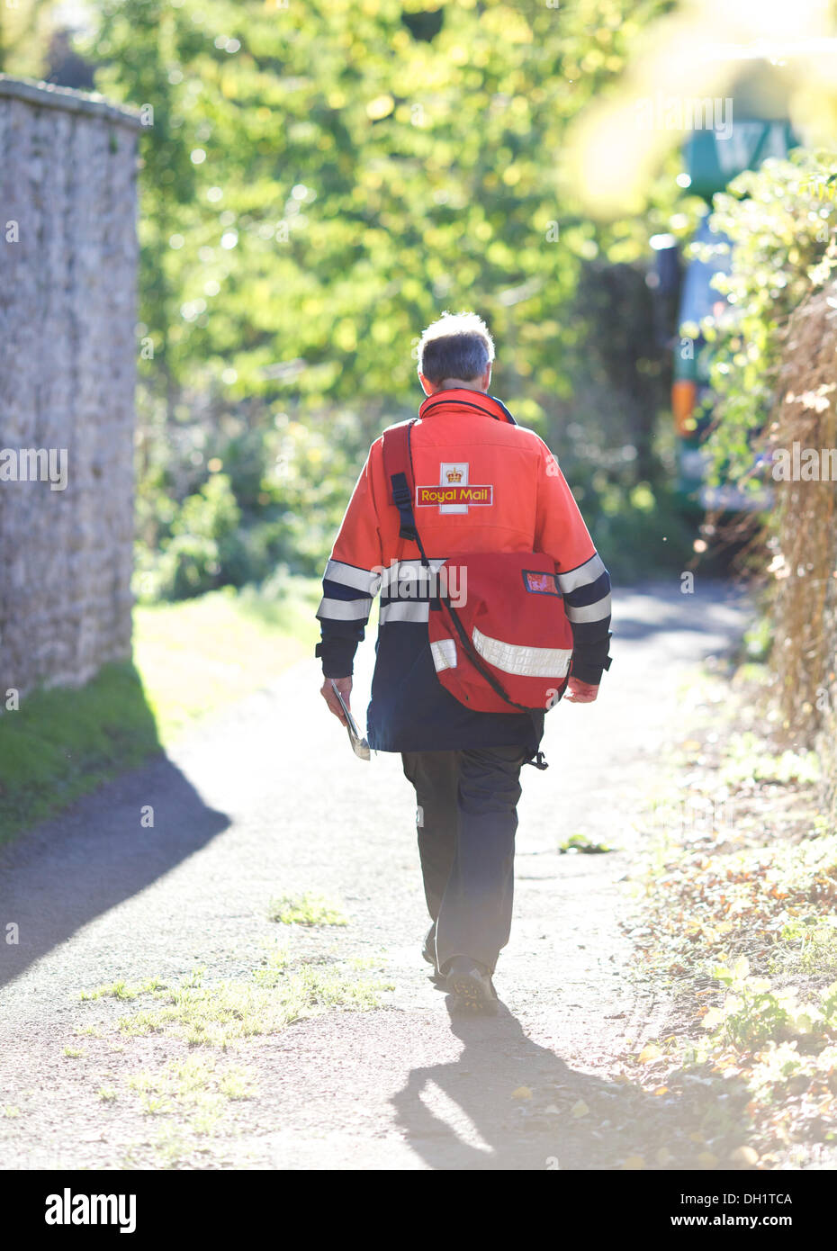 postman walking the street delivering mail Stock Photo - Alamy